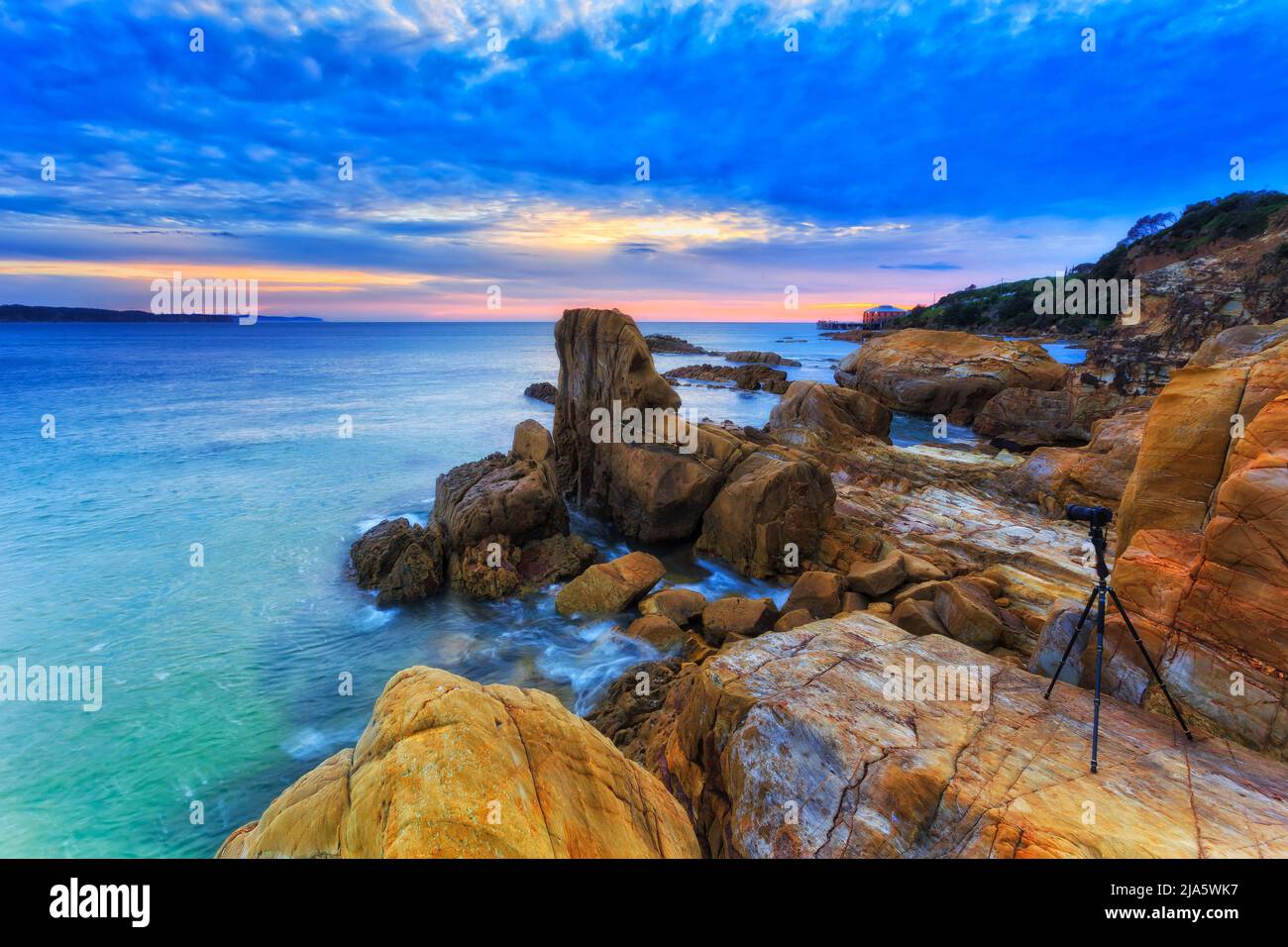 PHoto camera mounted on tripod at scenic sunrise in Tathra beach town ...