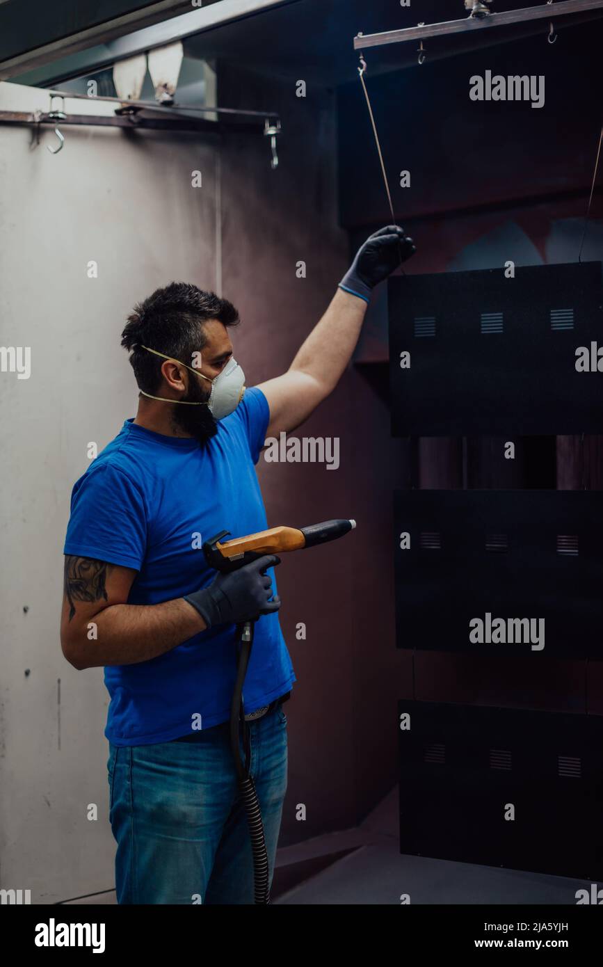 The painter paints the iron element. Industrial painting parts. Metal ...