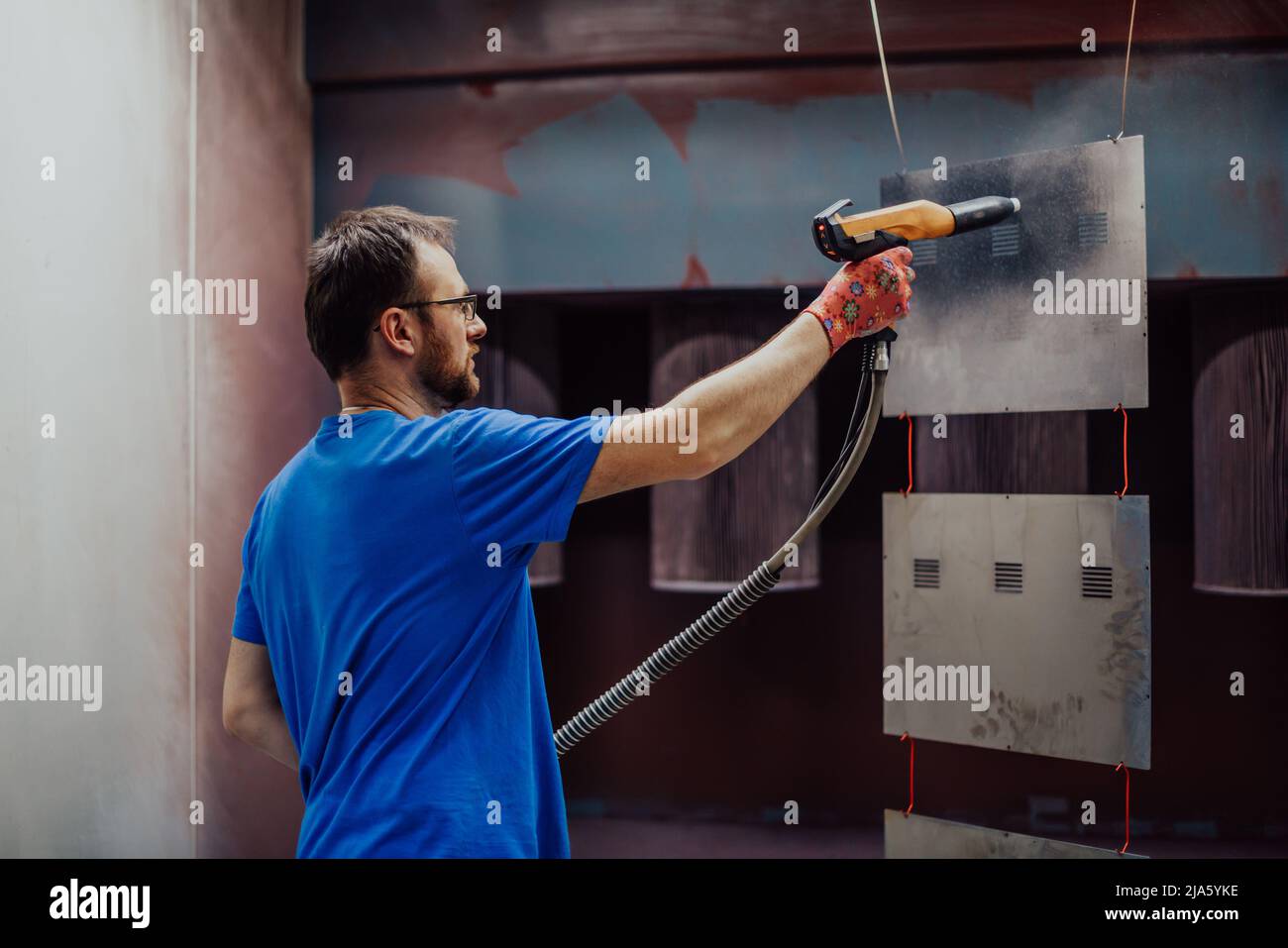 The painter paints the iron element. Industrial painting parts. Metal ...