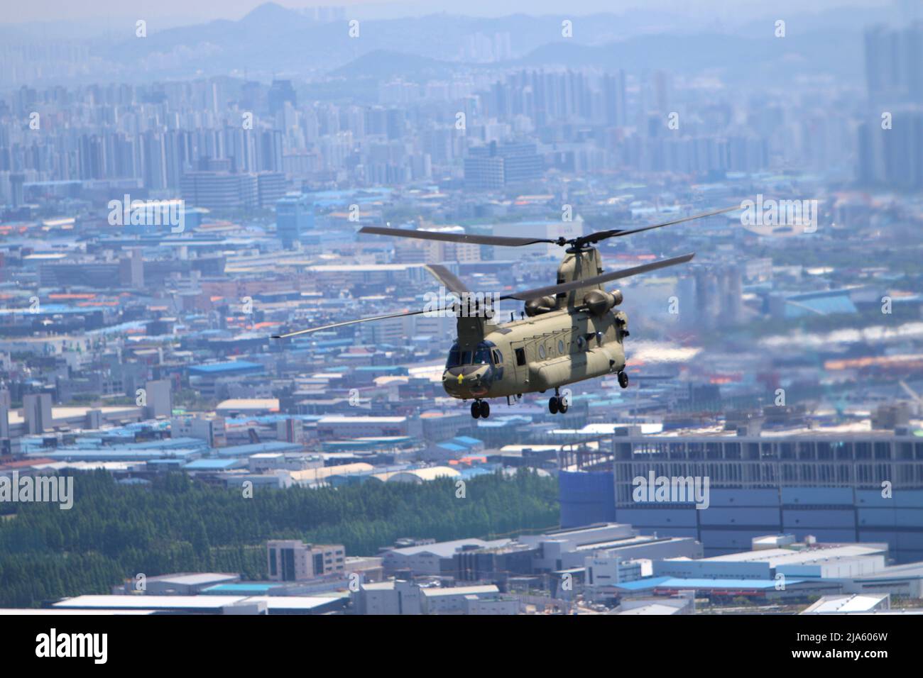 A CH-47F Chinook helicopter flies over the city of Incheon with ...