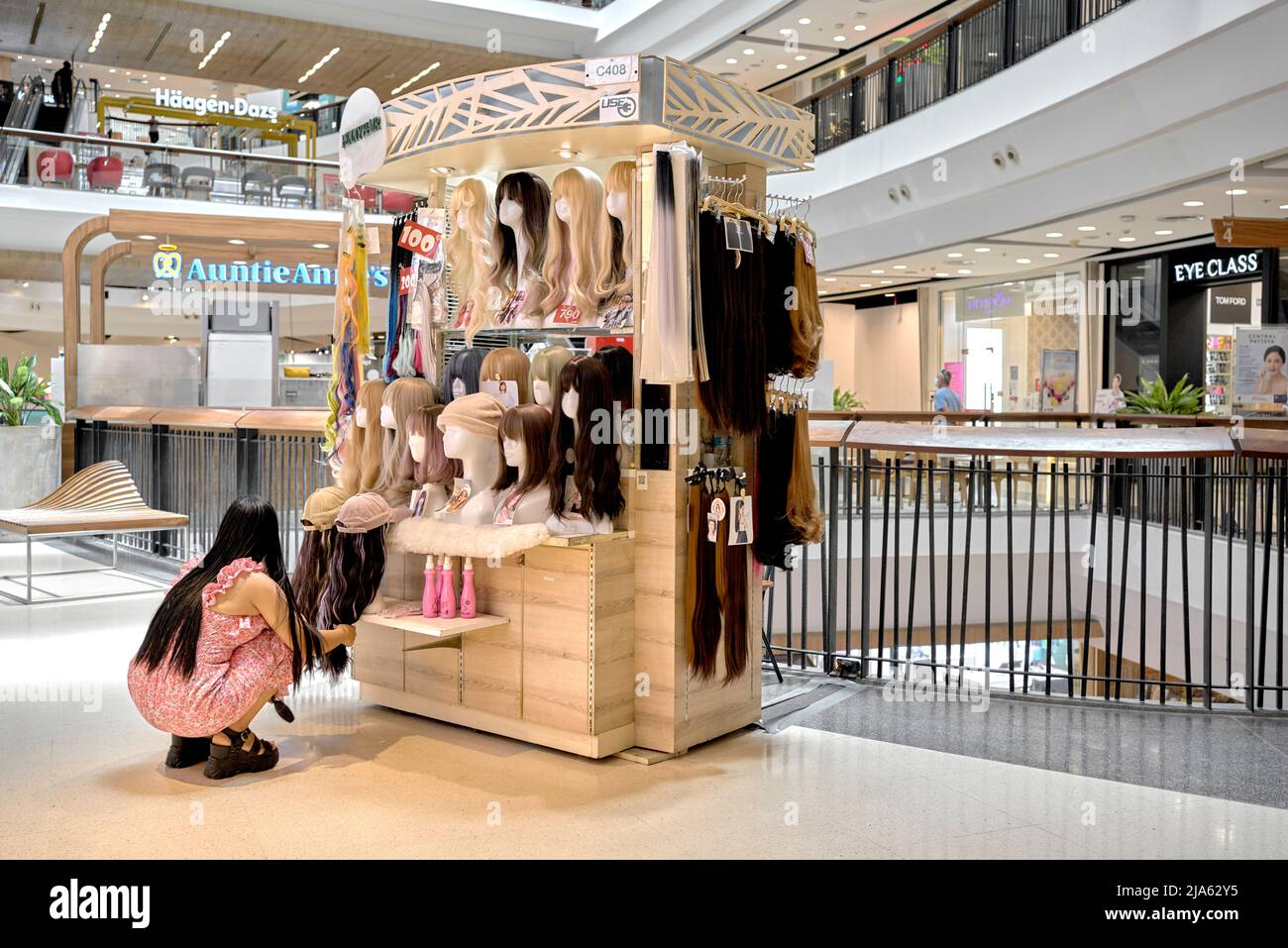 Wigs on display with female hair pieces and extensions in a shopping ...