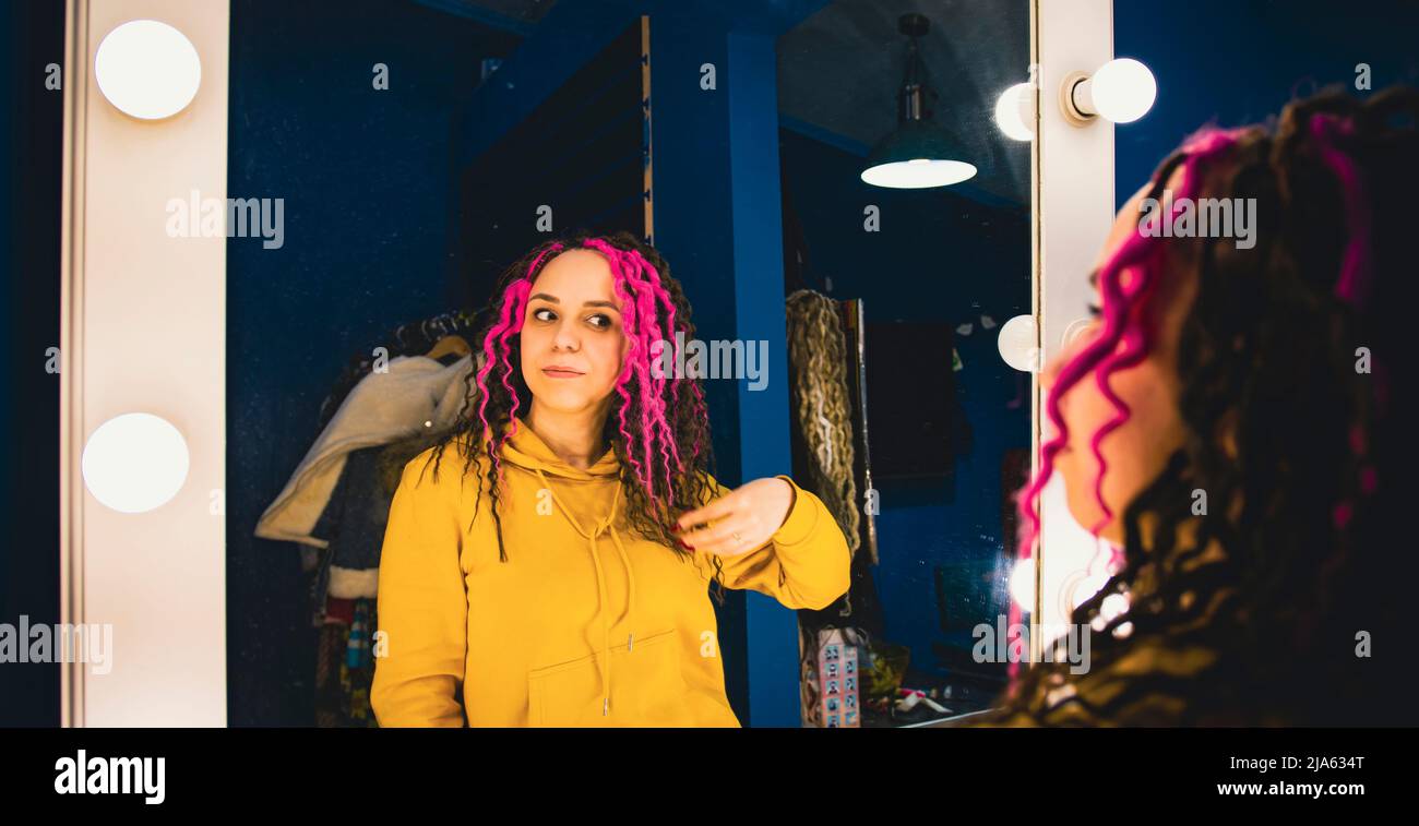 Beautiful female with dreadlocks preening in front of mirror Stock ...