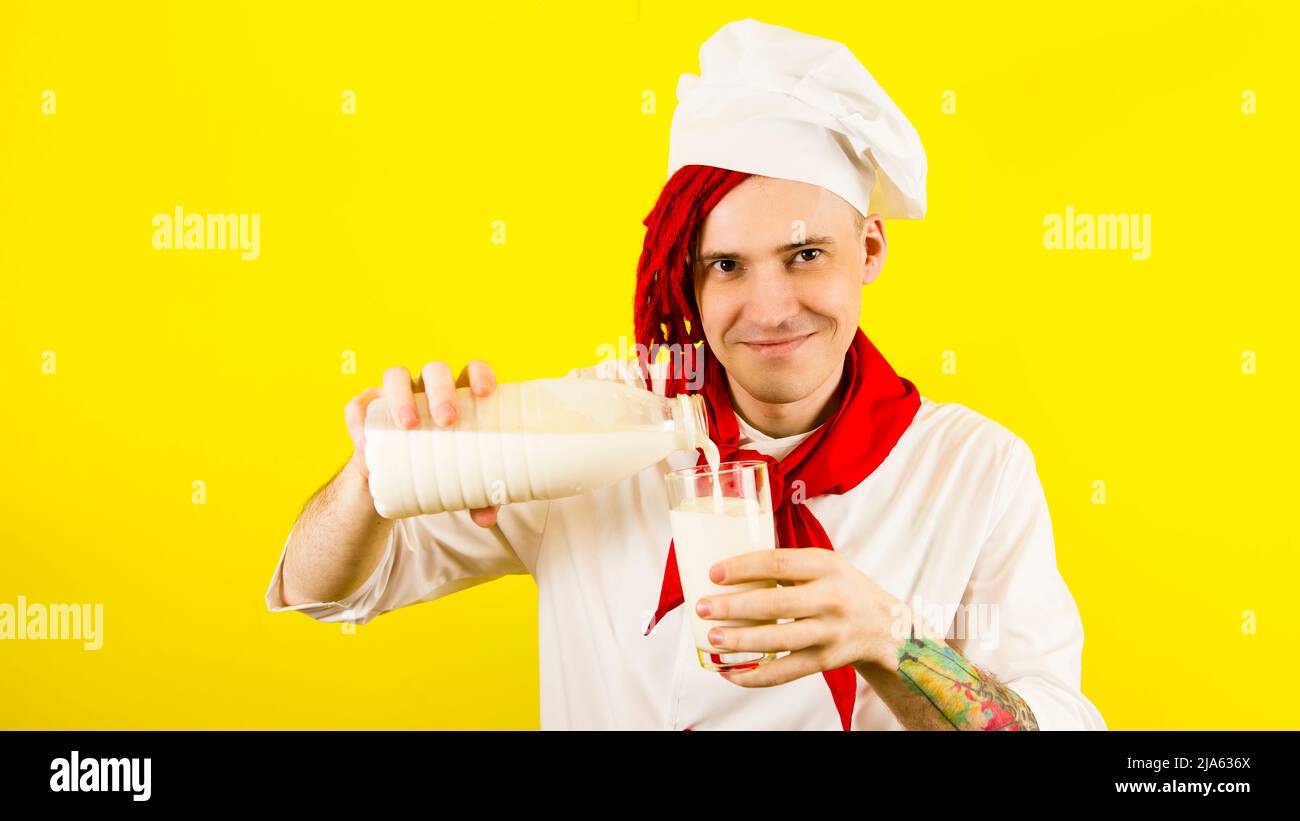 Man with red dreadlocks with bottle milk. Confident young cook in white ...