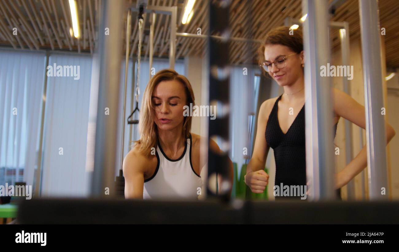 Young women doing fitness in the gym. A woman doing strength exercises ...