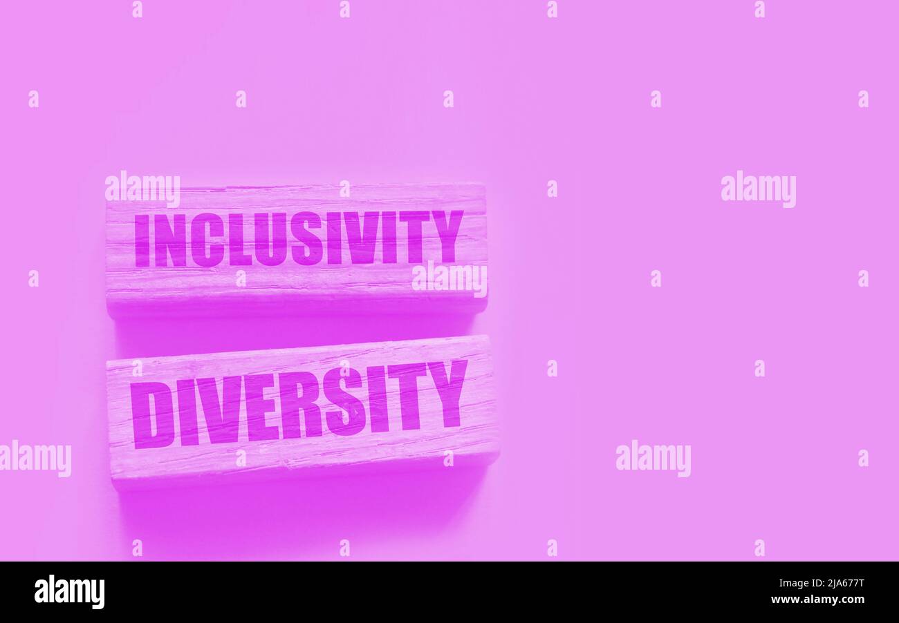 Inclusivity diversity words on wooden block on the yellow background ...