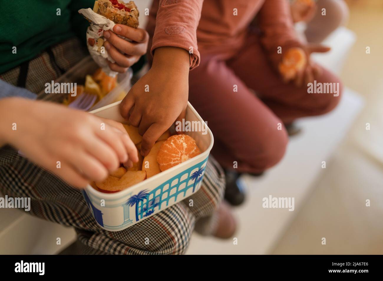 Group of classmates having fruit snack during break at school Stock ...