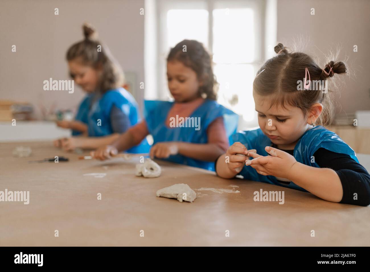 Group of little kids working with pottery clay during creative art and ...