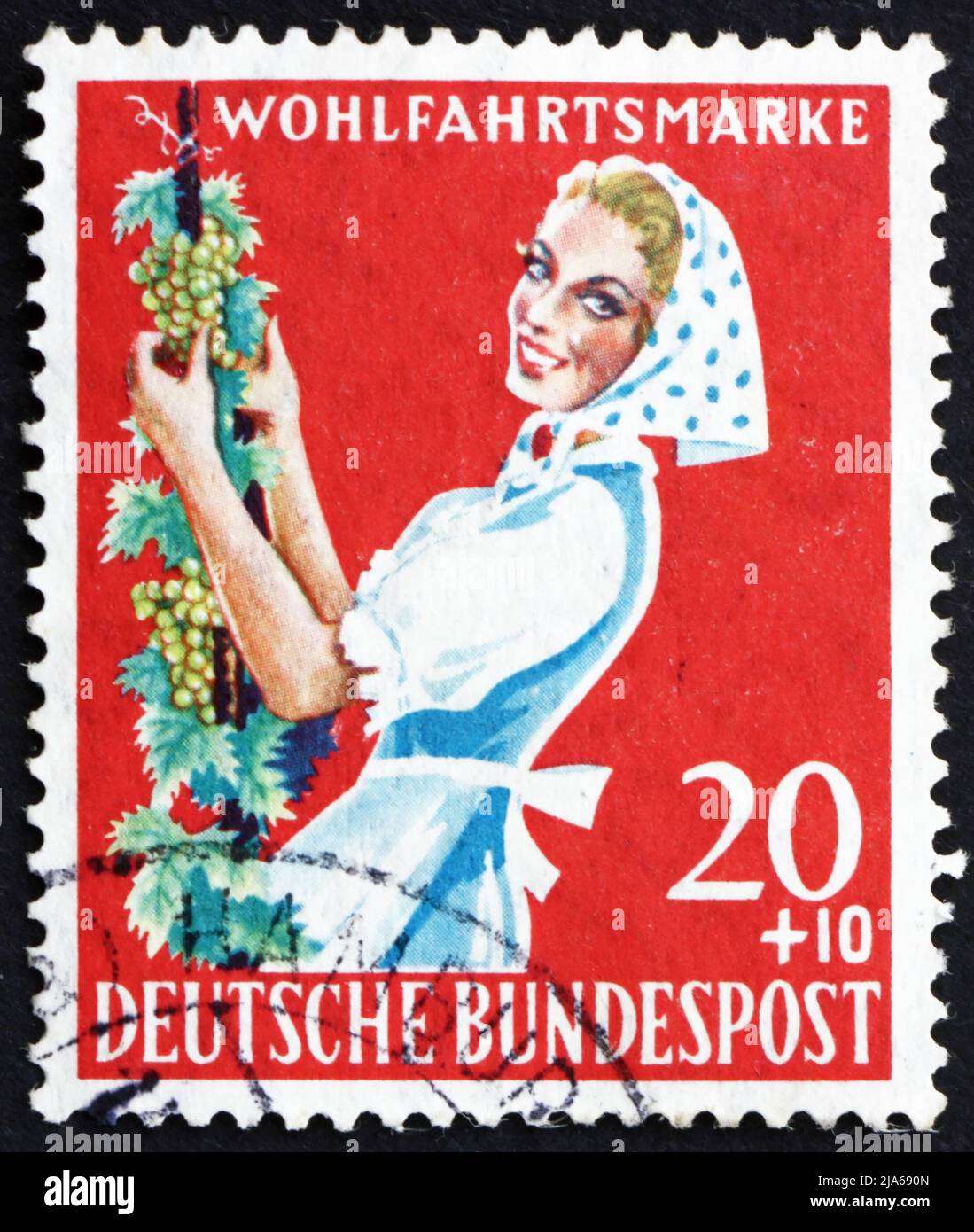 GERMANY - CIRCA 1958: a stamp printed in the Germany shows Girl Picking ...