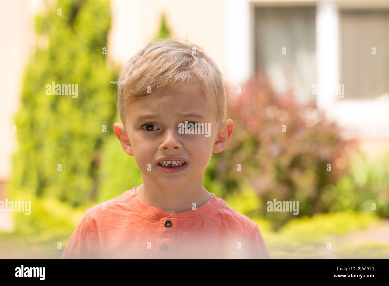 five-year-old boy making faces. A five-year-old blond boy makes faces ...