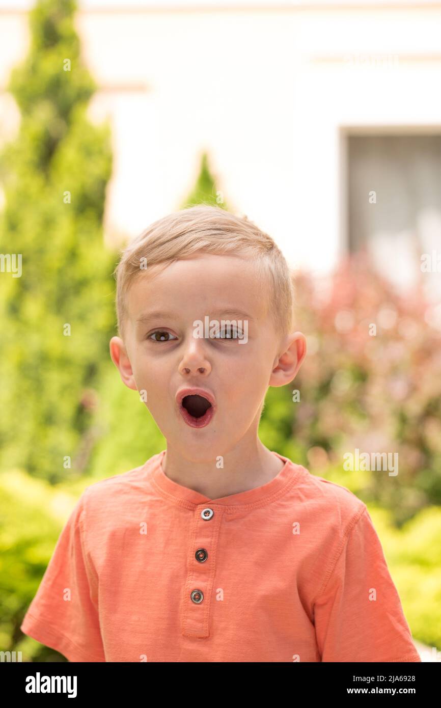 five-year-old boy making faces. A five-year-old blond boy makes faces ...