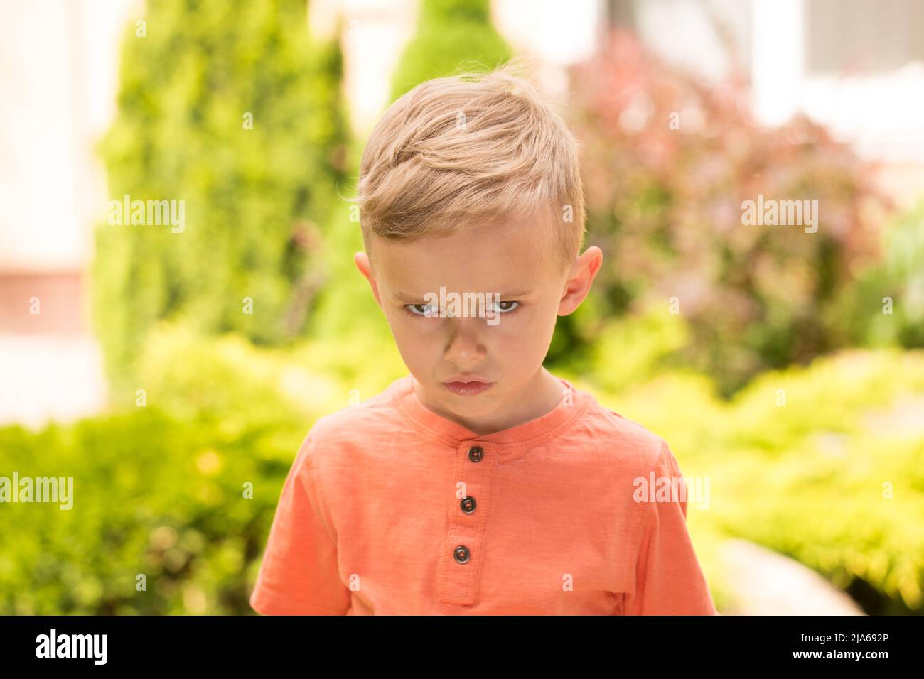 five-year-old boy making faces. A five-year-old blond boy makes faces ...
