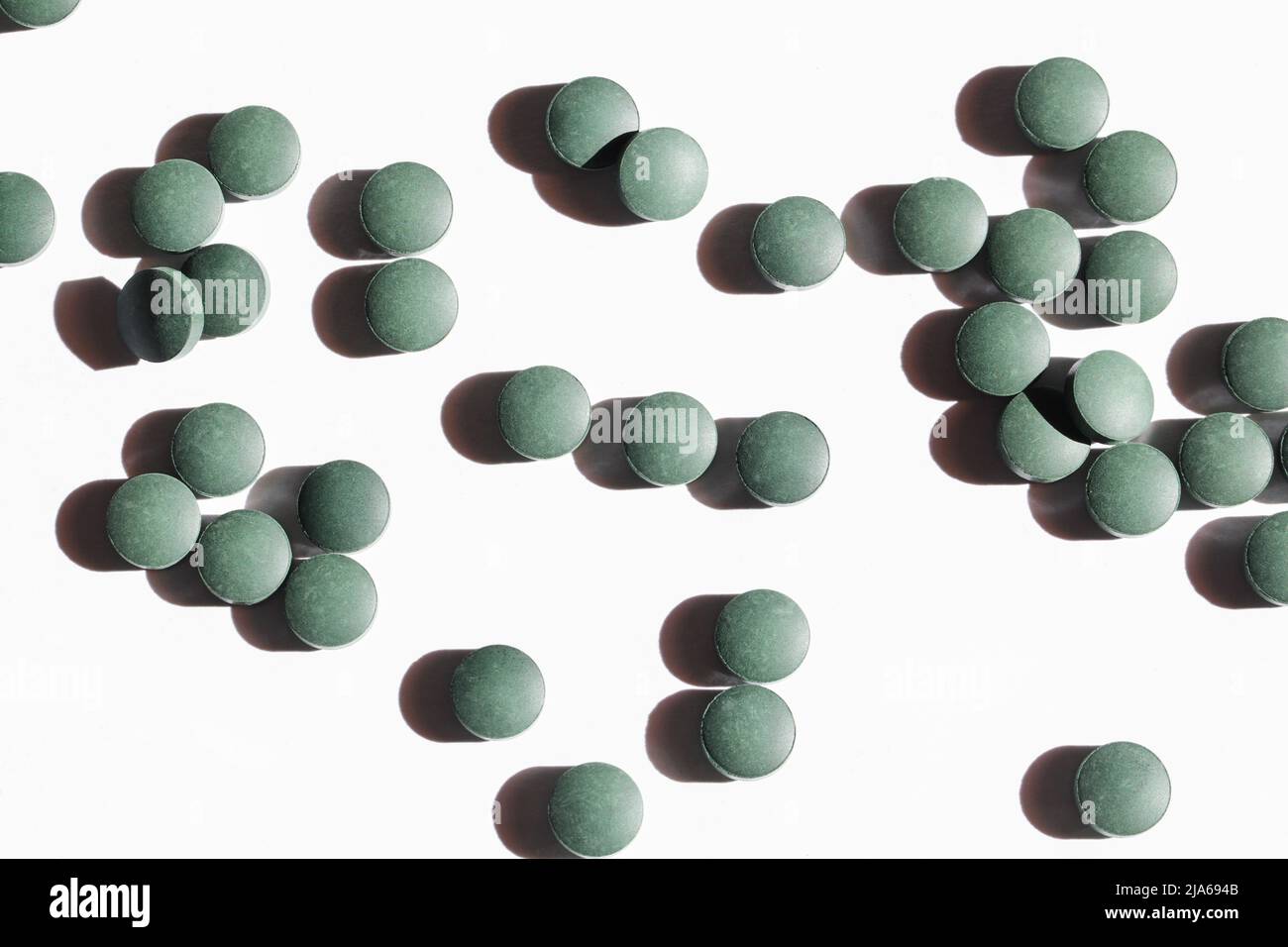 natural additives and superfood. green spirulina algae pills on white ...