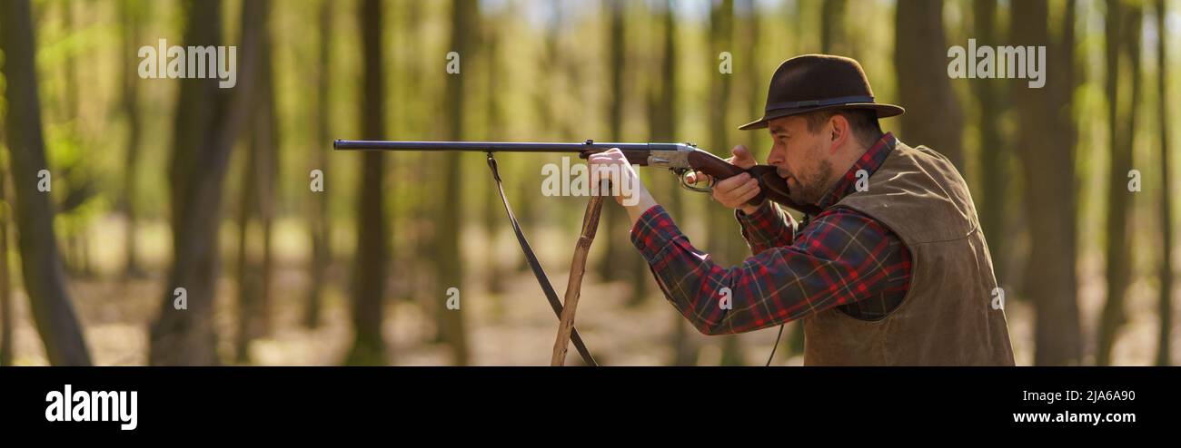 Side view of hunter man aiming with rifle gun on prey in forest Stock ...