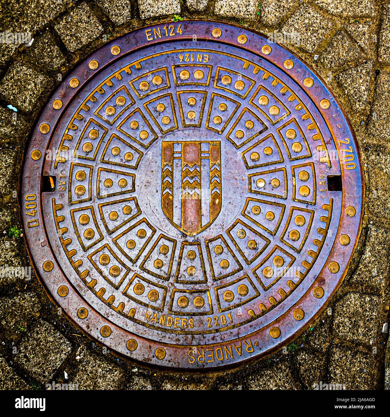 the metal cover of the sewer manhole is covered with sand. Warm toning ...