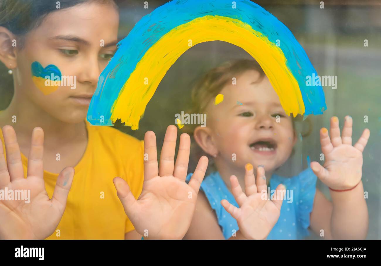 Children on the window painted a rainbow Ukraine peaceful sky ...