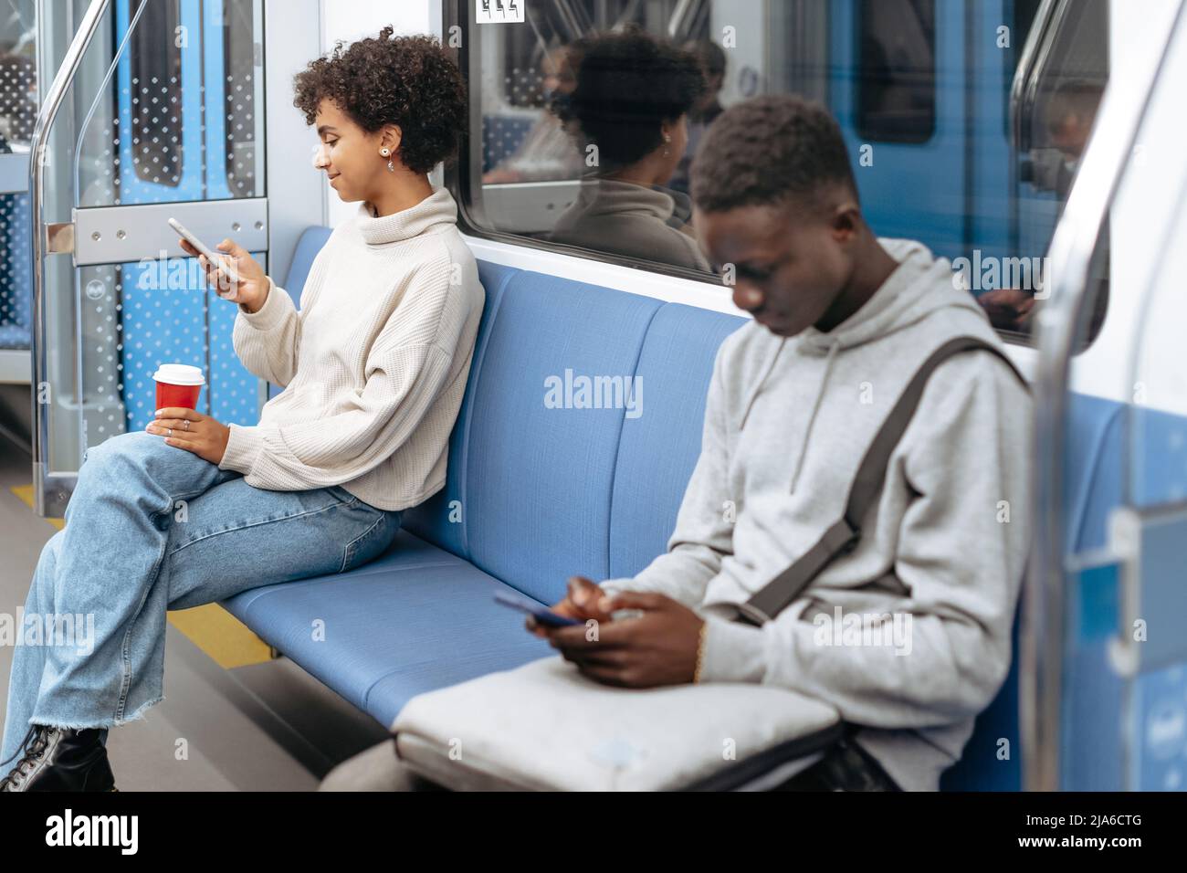 random subway passengers using their smartphones while sitting i Stock ...