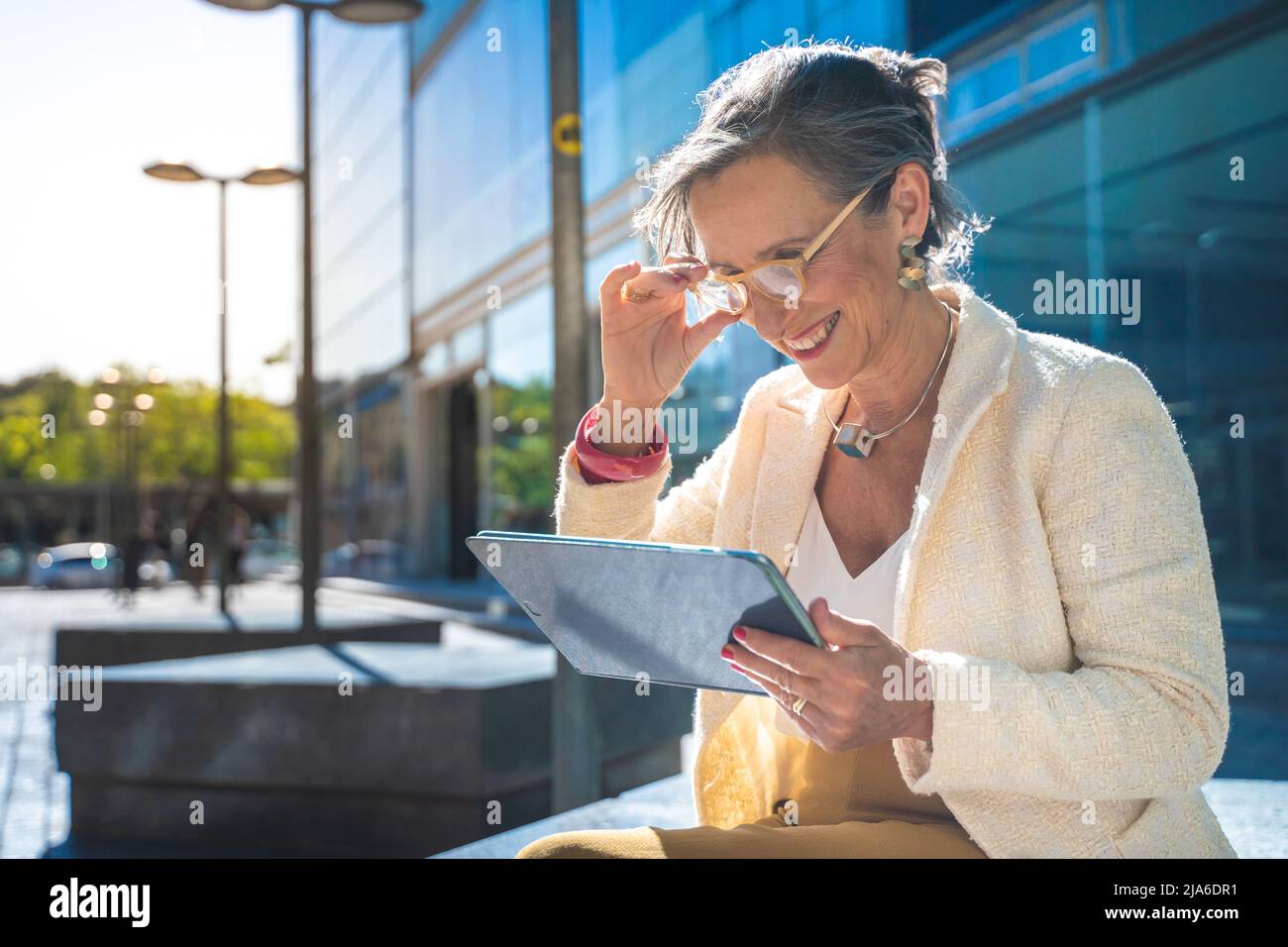 Senior business woman with technology happy working with a tablet in a ...