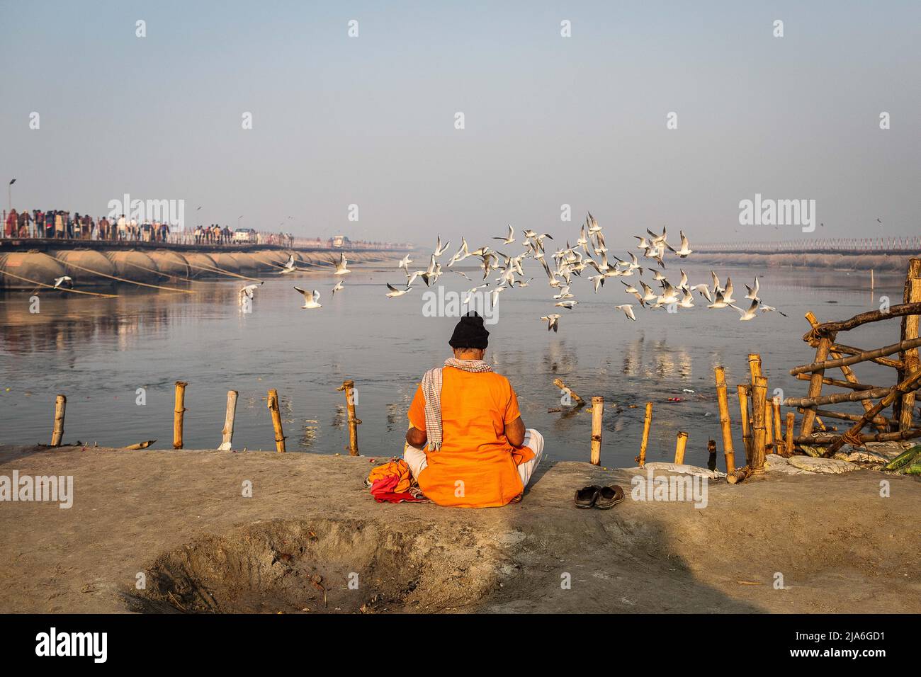 A pilgrim meditates on the bank of the Ganges river during the Kumbh ...