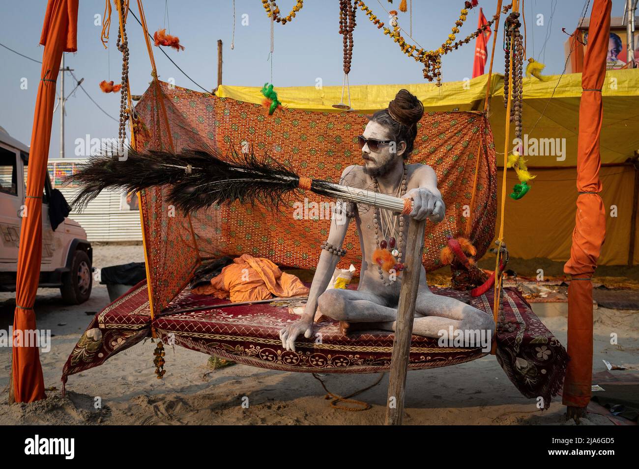 A naga sadhu sits on his swing during the Kumbh Mela festival. Every ...