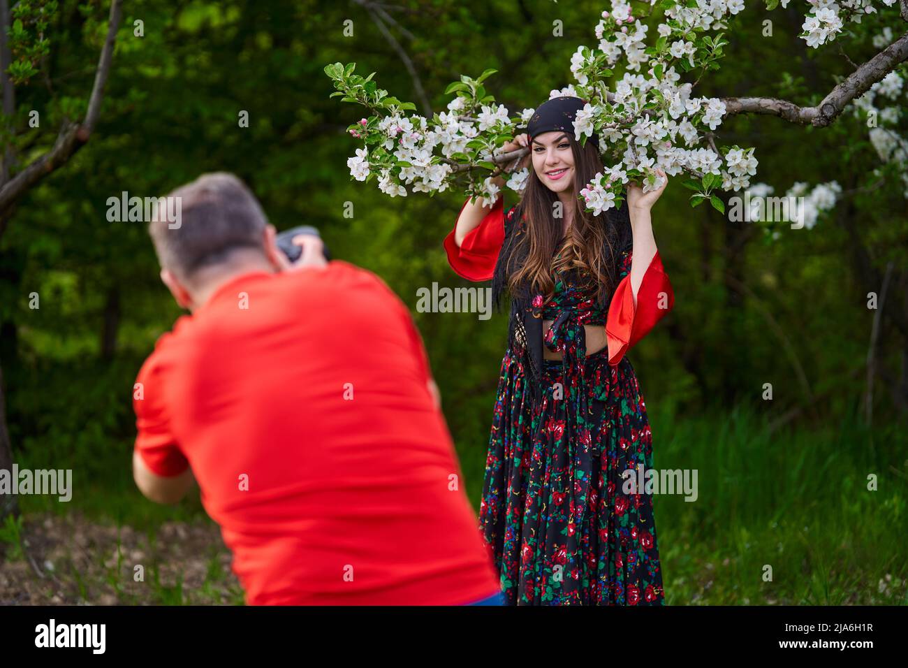 Photographer with his gypsy model shooting in an orchard Stock Photo ...