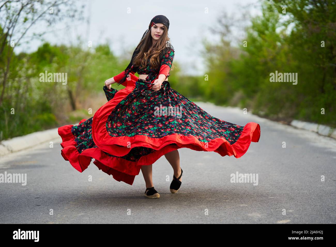 Young beautiful gypsy woman dancing in the middle of the street, in ...