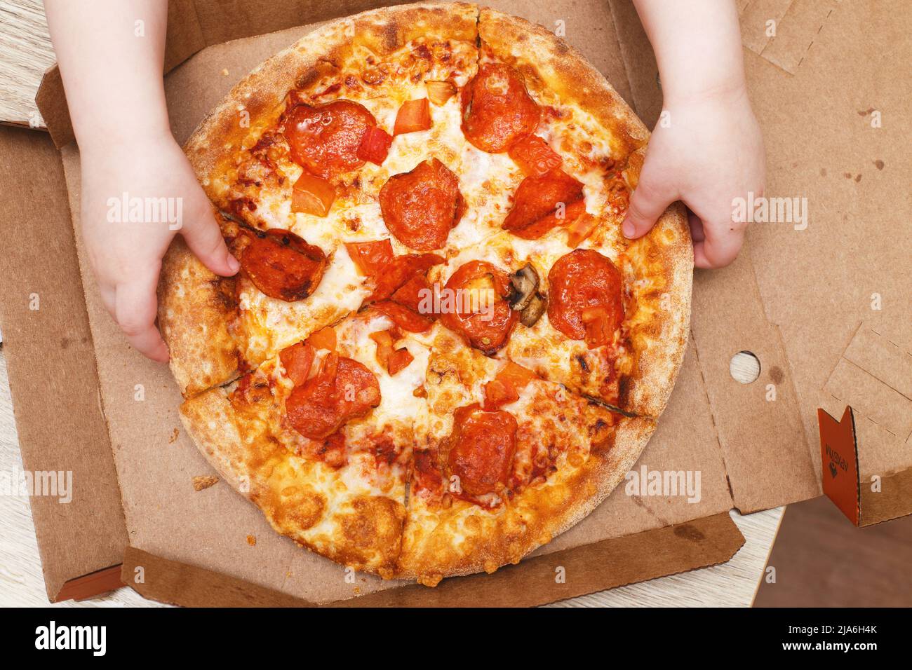 children's hands hold pizza in a cardboard box Stock Photo - Alamy