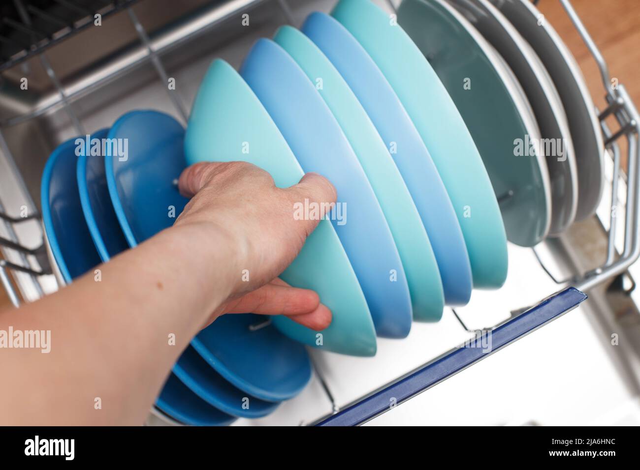 hand of a woman open dishwasher with a clean dishes in the kitchen ...