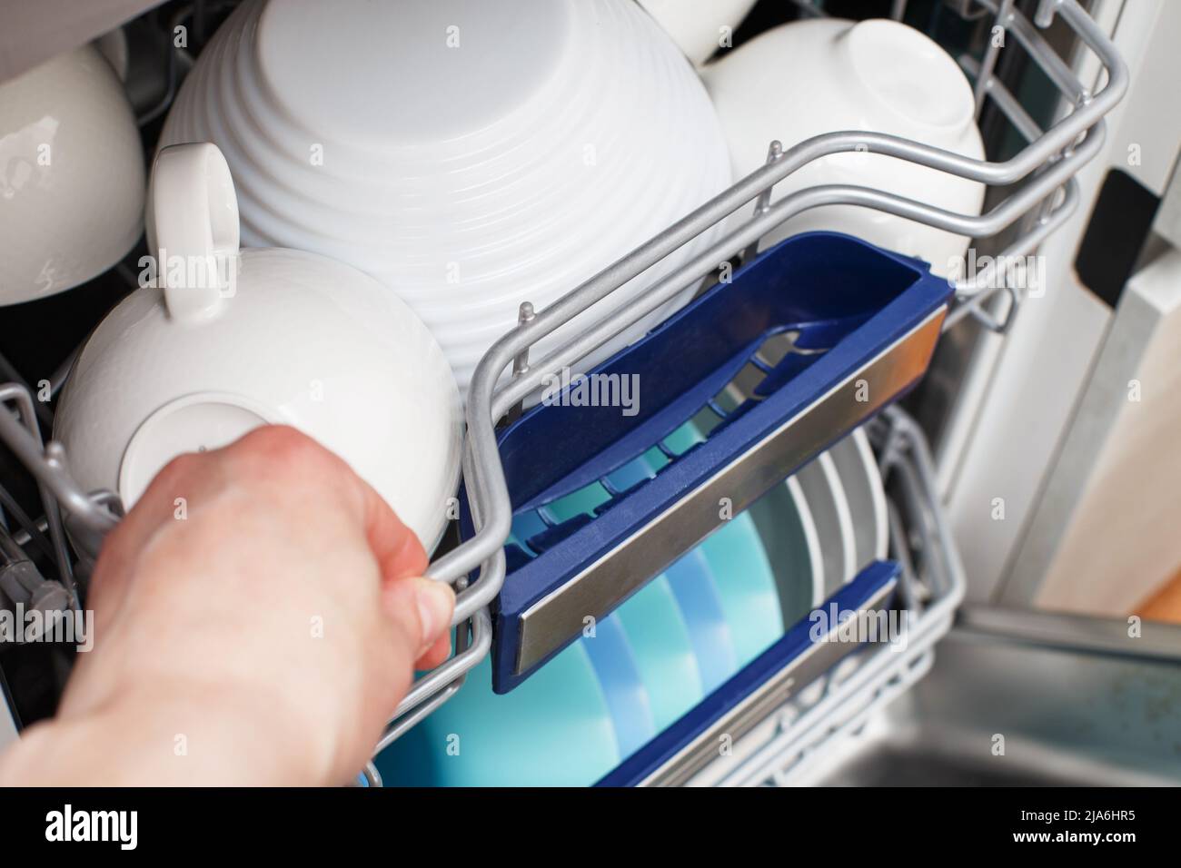 hand of a woman open dishwasher with a clean dishes in the kitchen ...