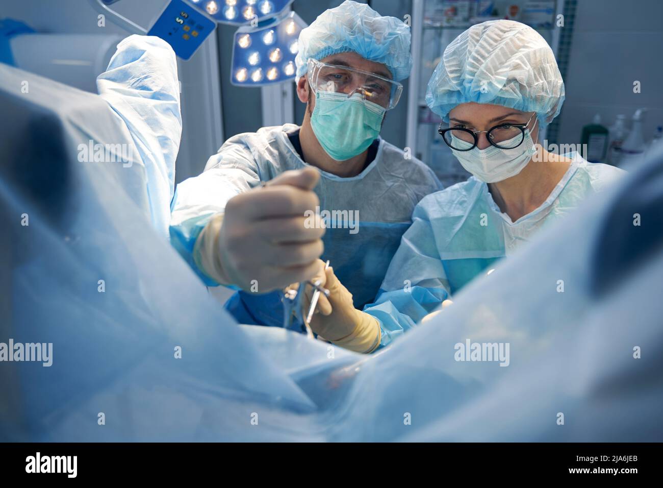 Two surgery professionals making operation in pelvic area Stock Photo ...