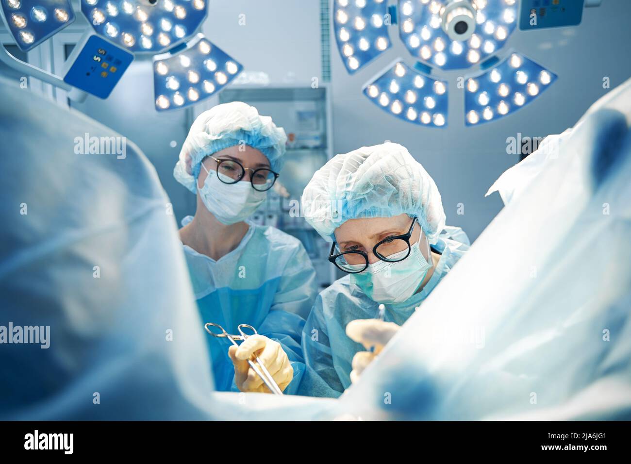 Senior surgeon operating with scissors and laparoscopic tool Stock ...