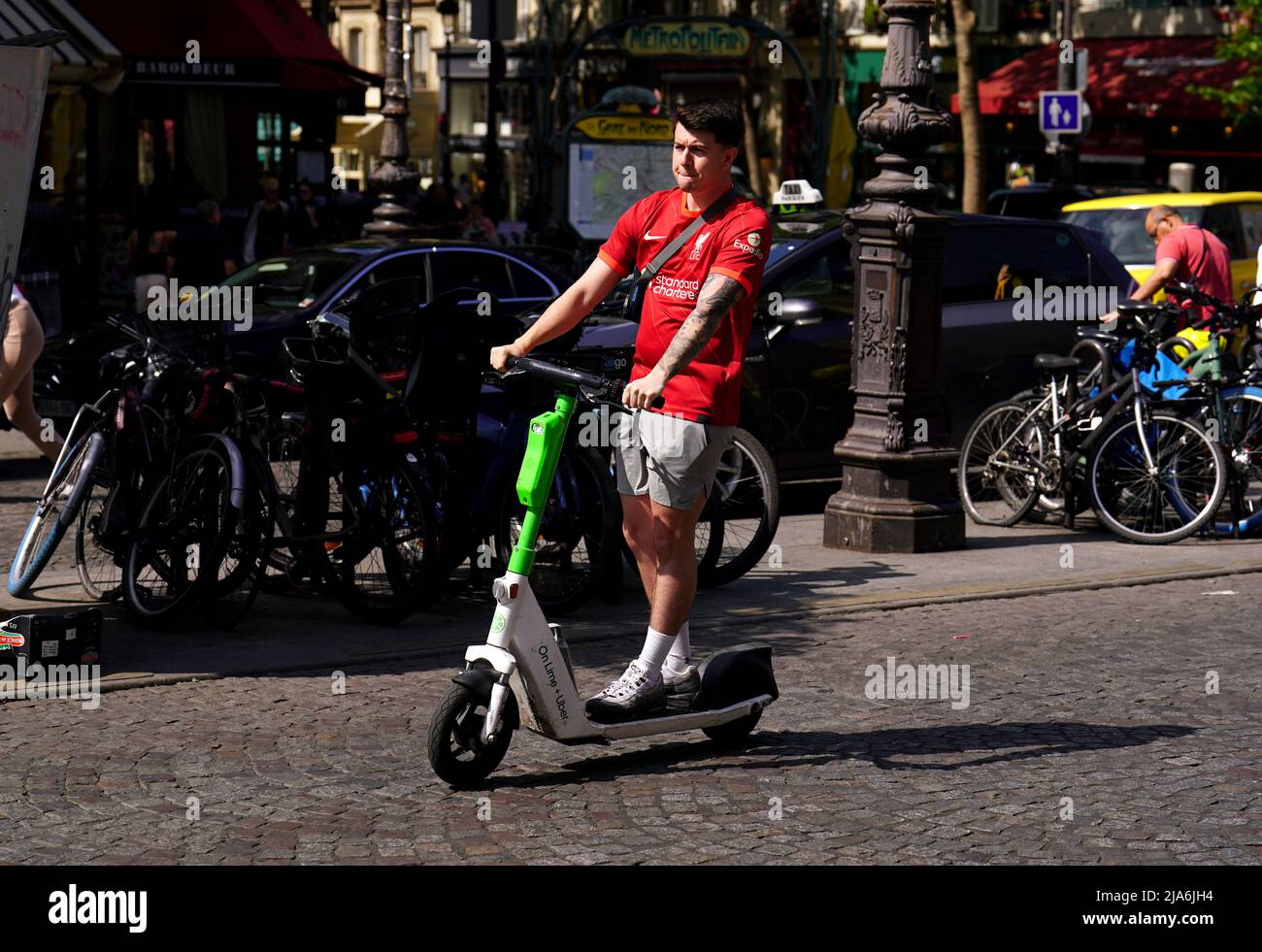A Liverpool fan rides a scooter down a street ahead of the UEFA ...