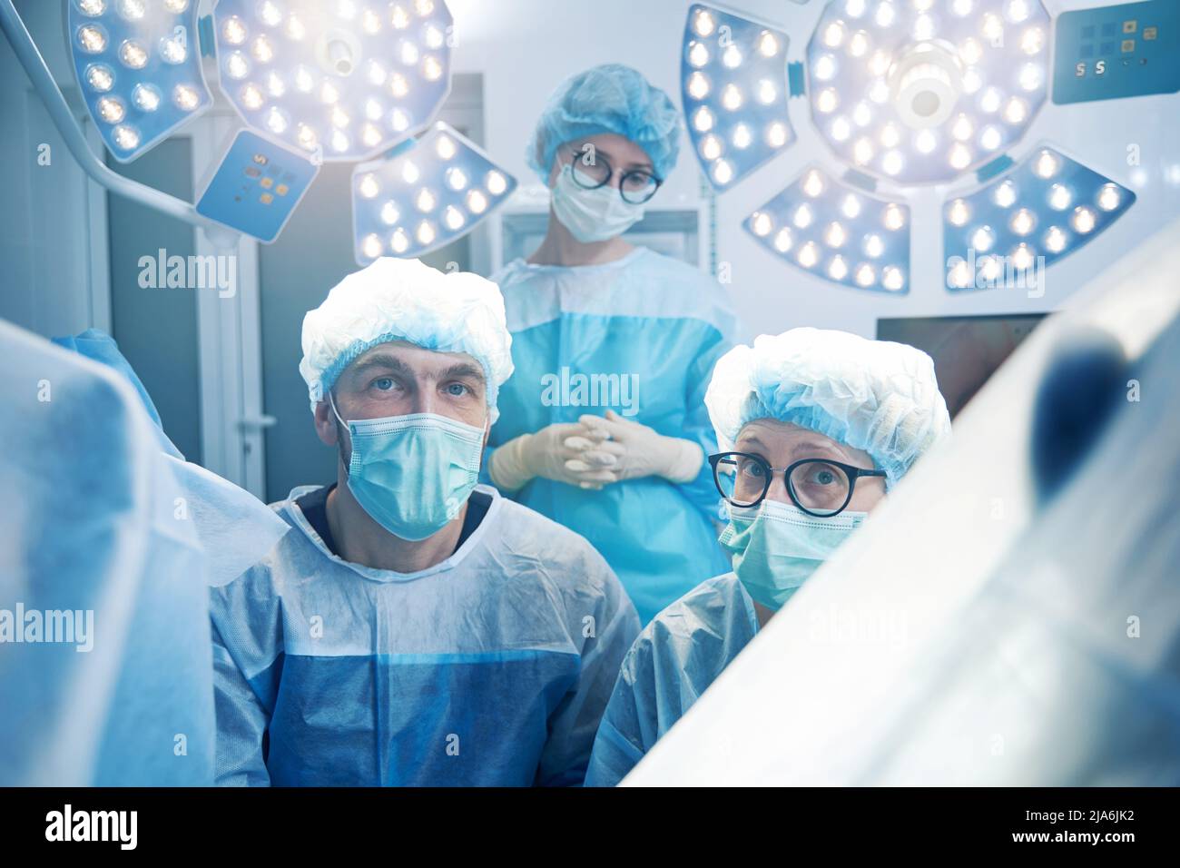 Surgical team of three people staring at camera Stock Photo - Alamy