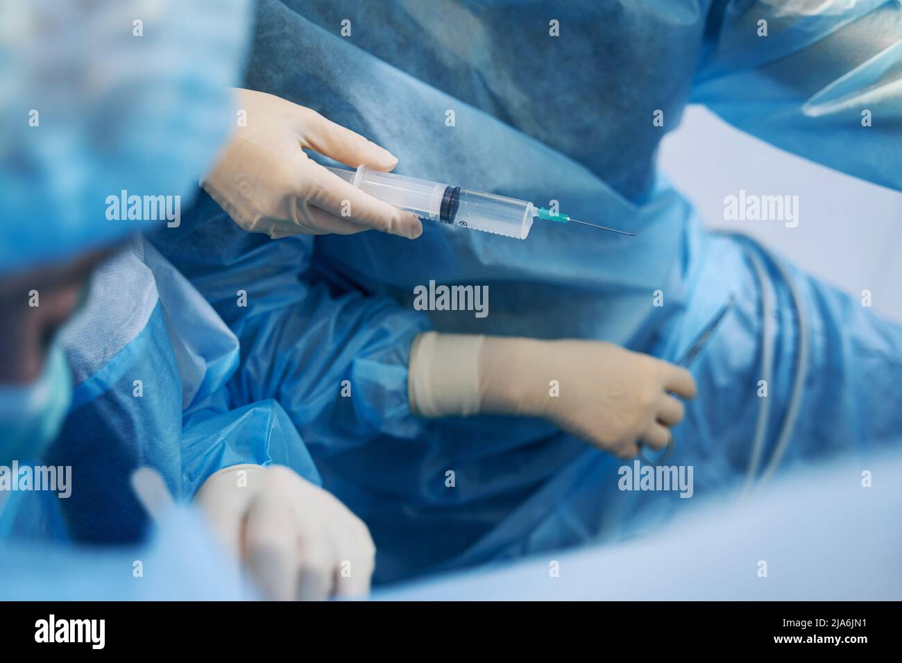 Doctor passing syringe with anesthesia during operation Stock Photo - Alamy