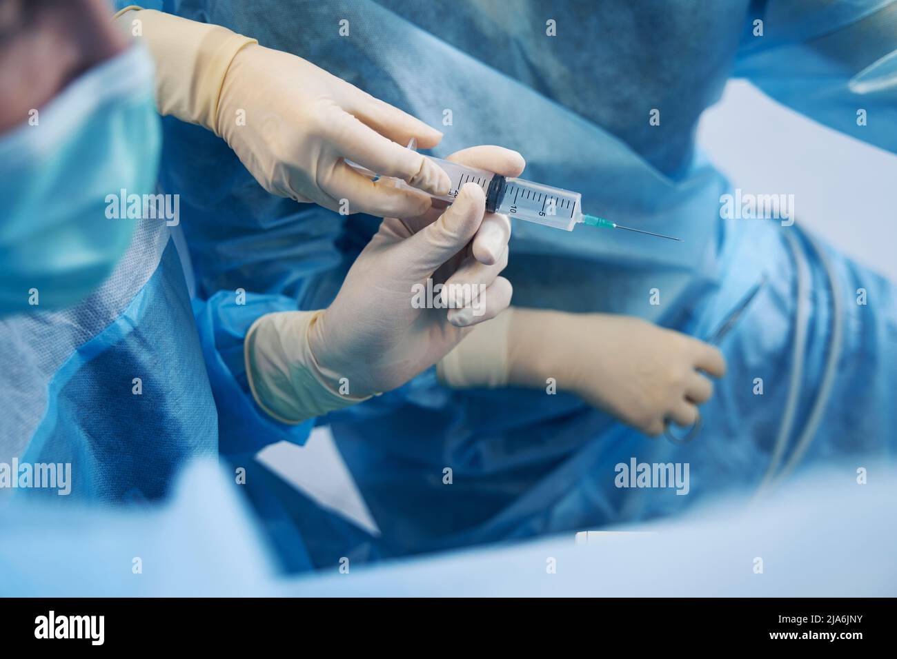 Surgical expert getting syringe with medication from circulating nurse ...