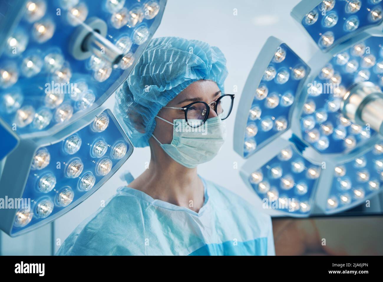 Smiling nurse monitoring operating porcess in surgery room Stock Photo ...