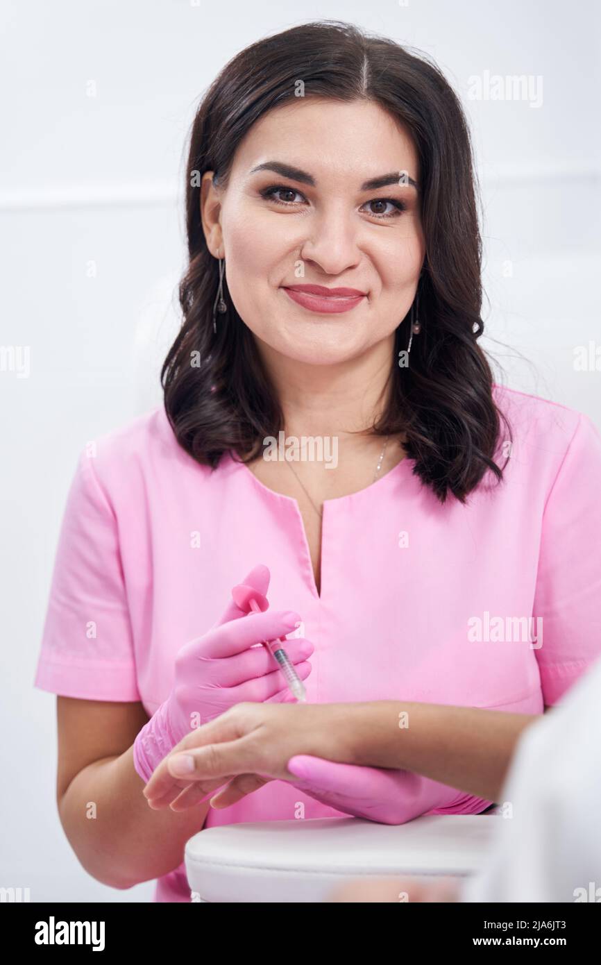 Woman health worker giving an injection to arm of patient Stock Photo ...