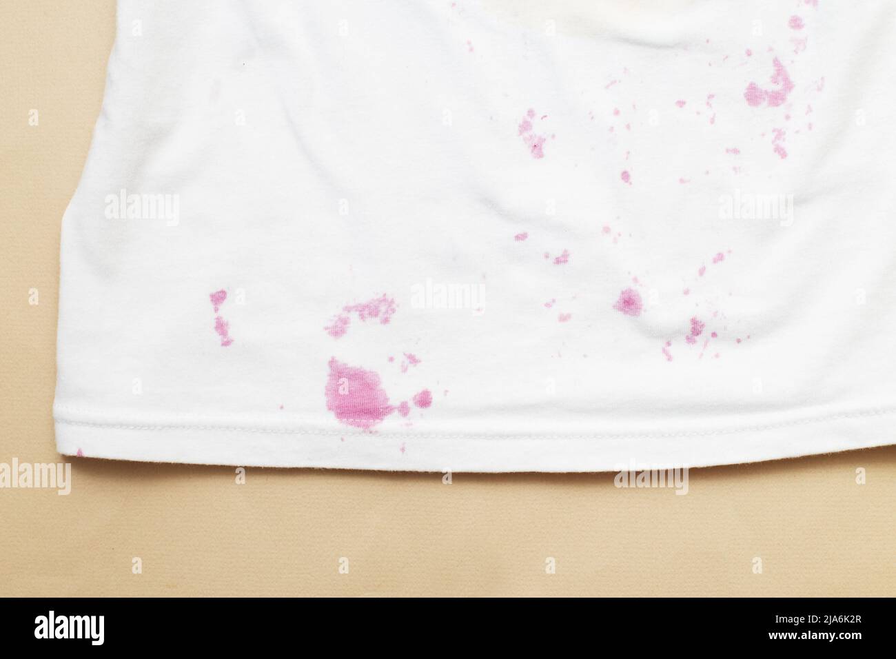dirty stains on a white T-shirt from berries and drink on beige ...