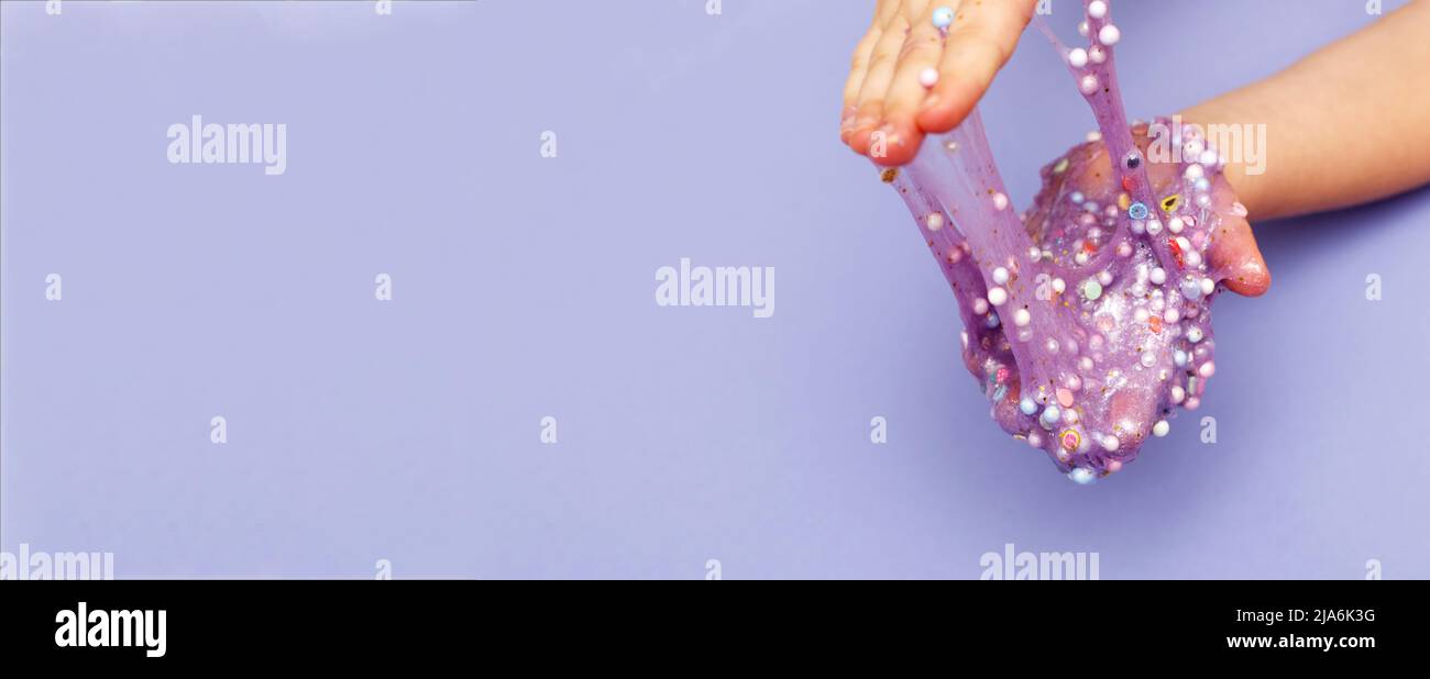 Making slime at home. child holding and stretching colorful slime. DIY ...