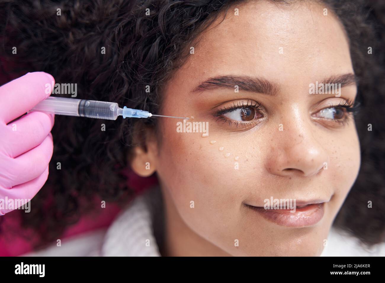 Cosmetologist is injecting beauty injection with syringe to young woman ...