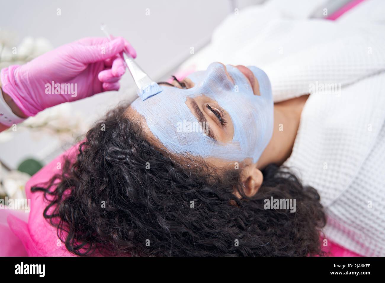 Young woman lying with open eyes and with facial mask Stock Photo - Alamy