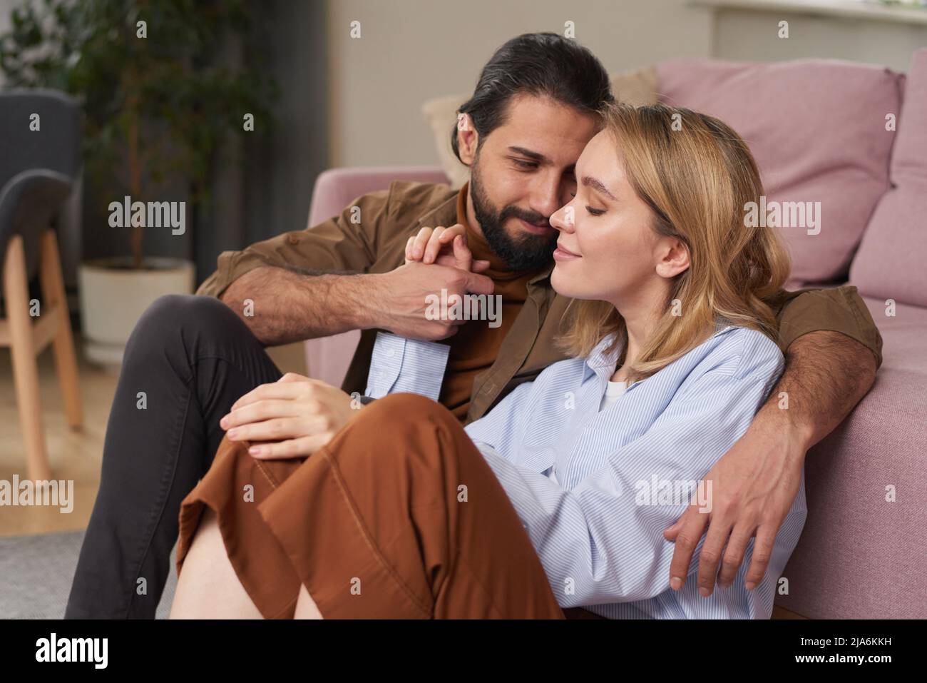 Handsome young man with beard on face spending time at home with his ...