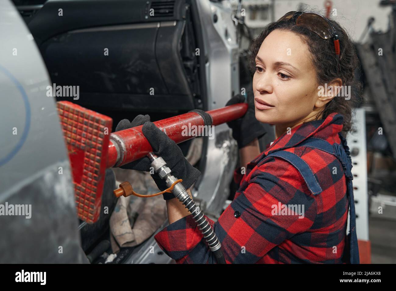 Female auto mechanic fixing car in automobile garage Stock Photo - Alamy