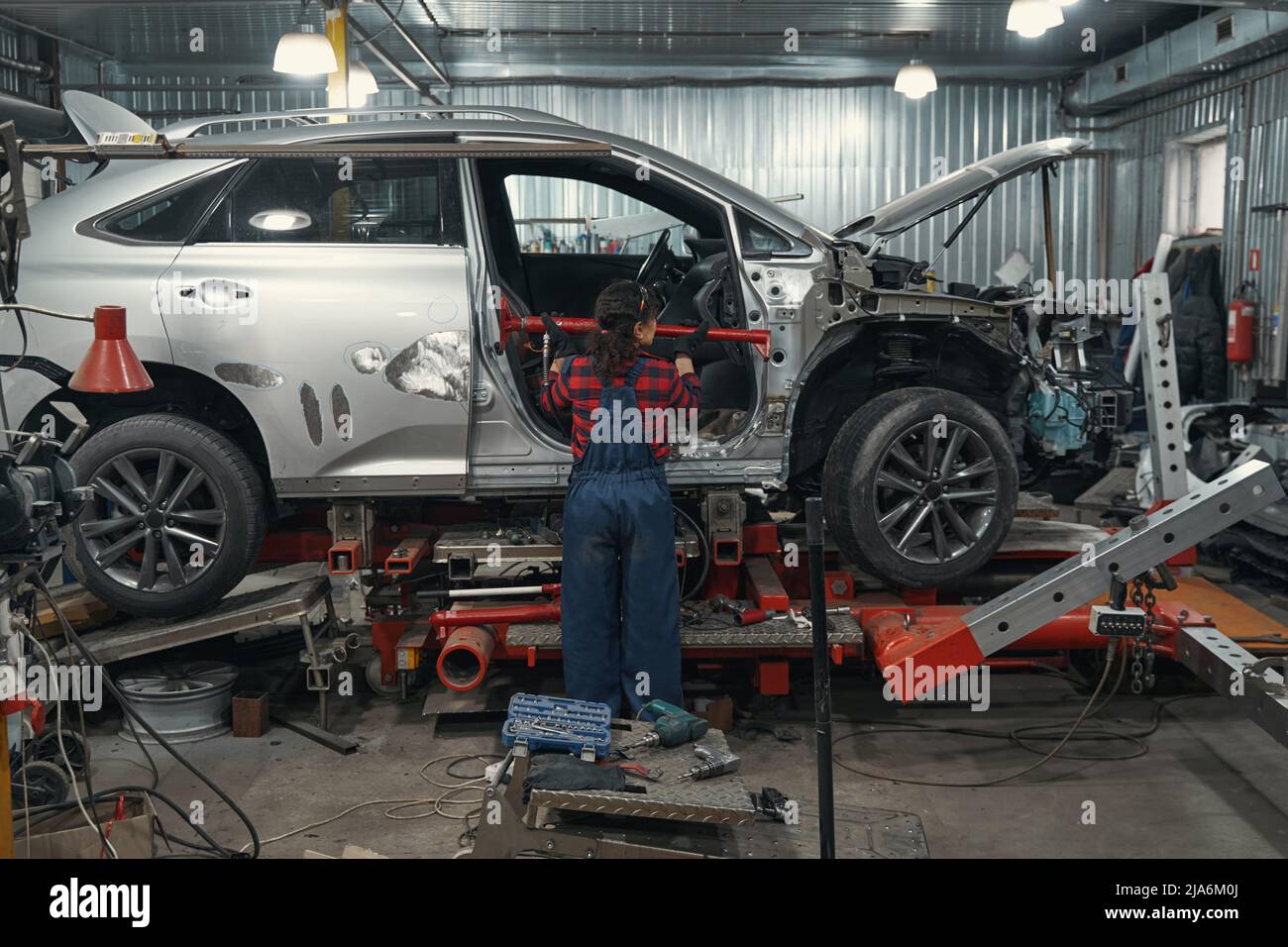 Female auto mechanic repairing vehicle in car garage Stock Photo - Alamy