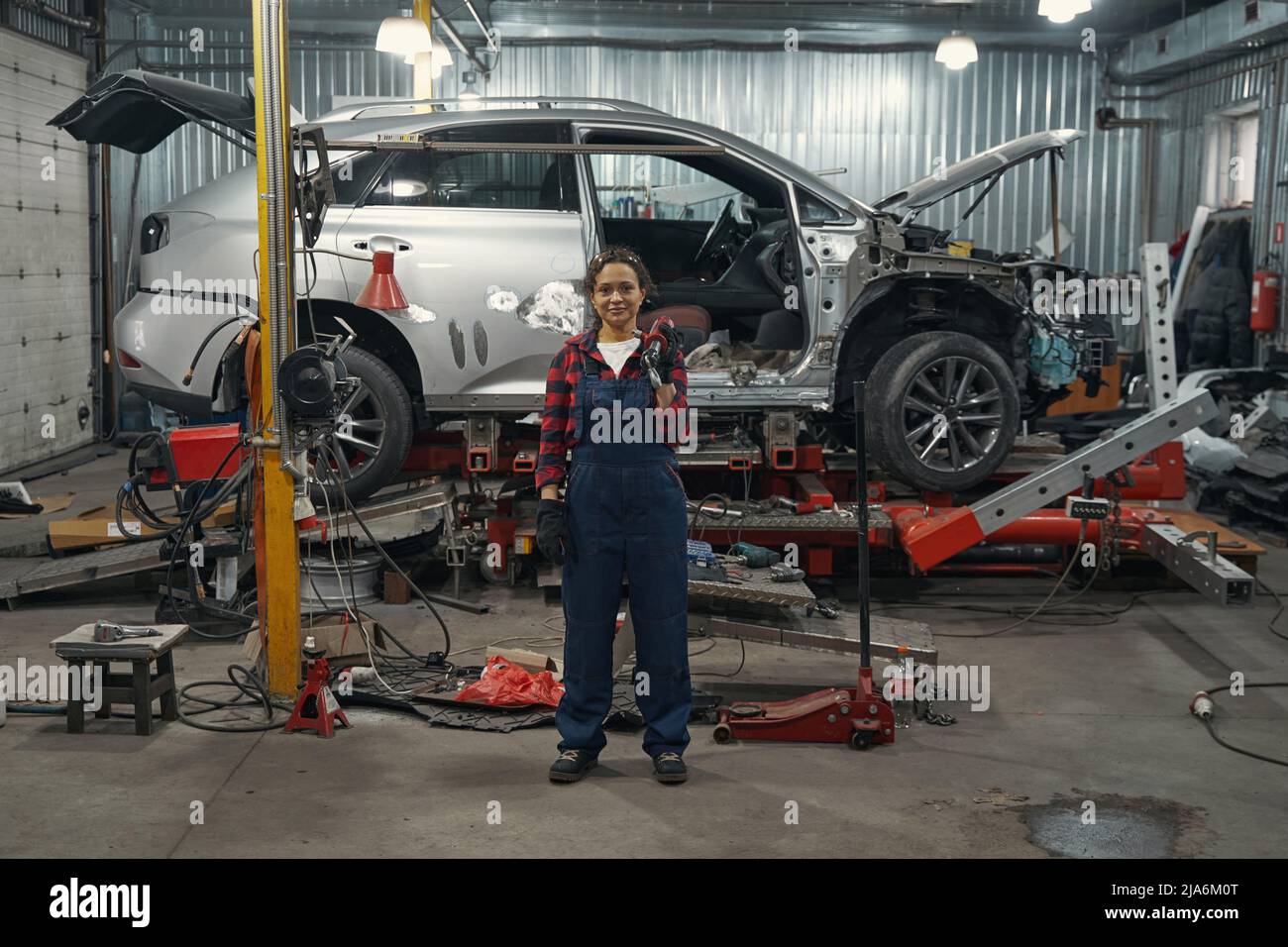 Woman auto mechanic standing near vehicle in car garage Stock Photo - Alamy