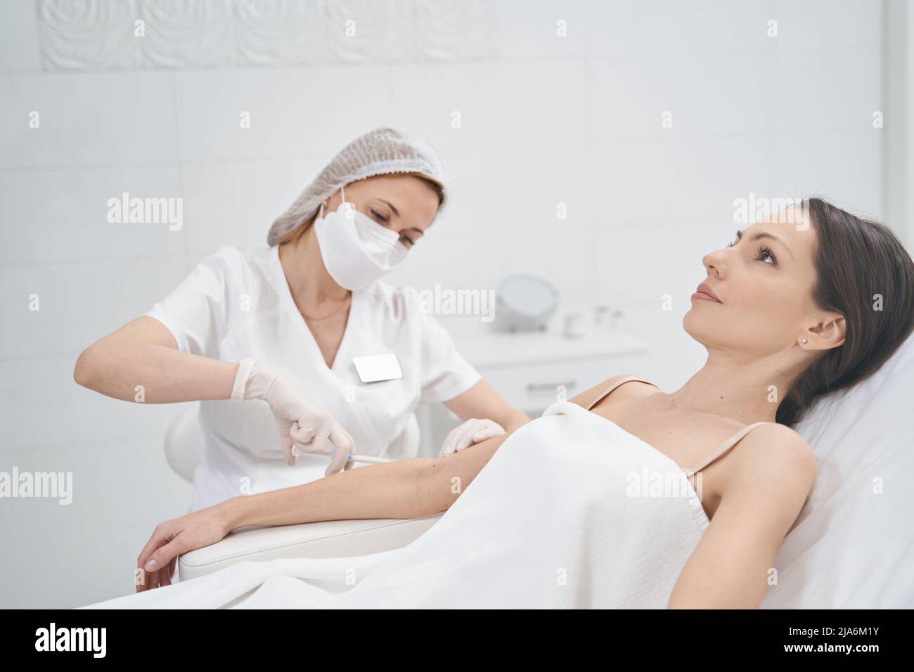 Doctor cosmetologist doing beauty injection into female arm Stock Photo ...