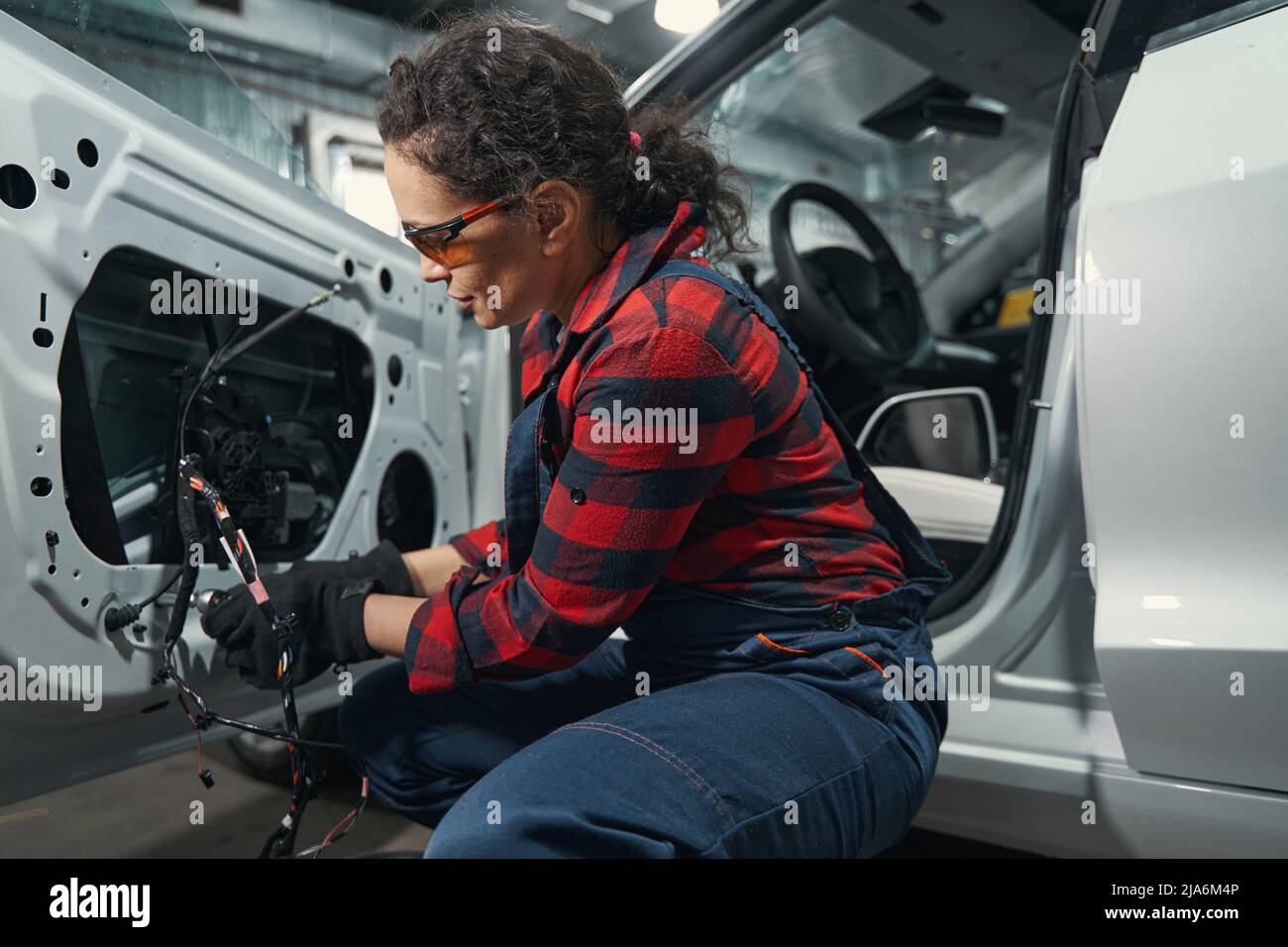 Female auto mechanic repairing car door in garage Stock Photo - Alamy