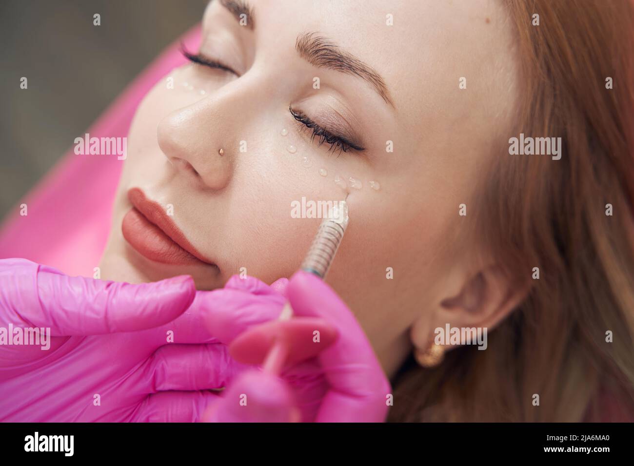 Beautiful female receiving anti-aging procedure with syringe in ...