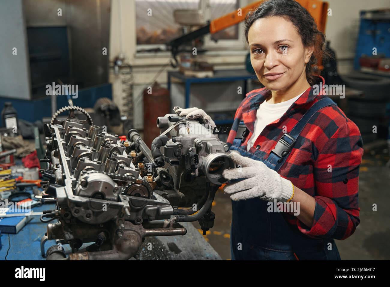 Female auto mechanic fixing car engine in repair service station Stock ...