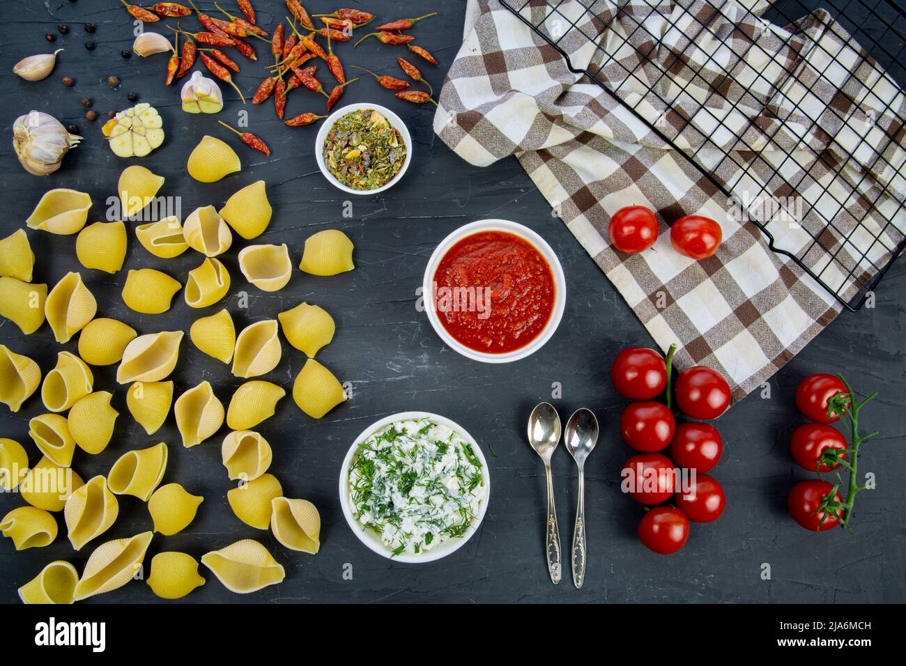 Stuffed conchiglie preparation, food ingredients on black concrete ...
