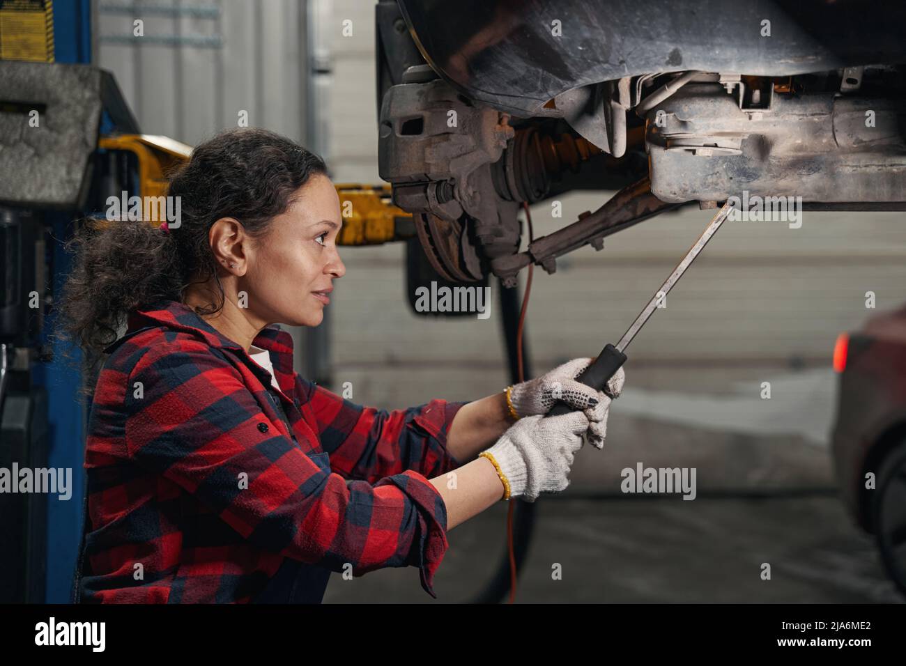 Female auto mechanic repairing automobile in garage Stock Photo - Alamy